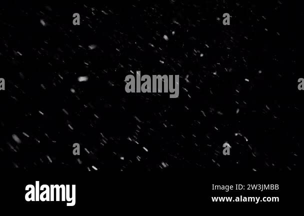 Snow falling from the sky isolated on the black background, seamlessly ...