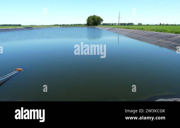 Irrigation reservoir with pipes. man-made special, water storage pool ...