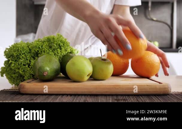 woman was picking an oranges and using a knife for cut the orange ...