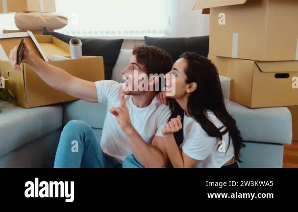 Young couple move into new apartment. Camera moves backwards from ...