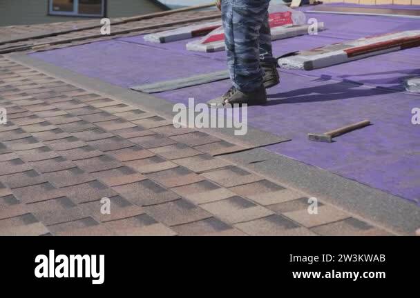 Roofing work. Laying a soft roof on the roof of a private house ...
