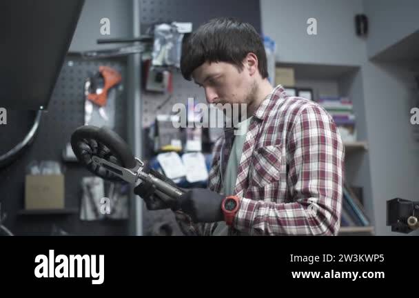 Electric scooter repair workshop. Mechanic holds in his hand broken ...
