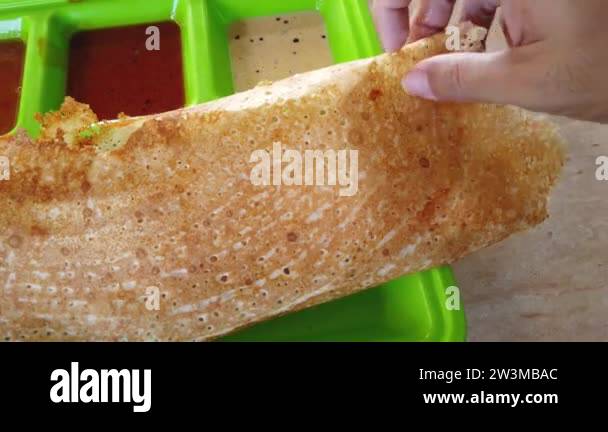 POV of a man eating thosai. A dosa (thosai, tosai) is a type of pancake ...