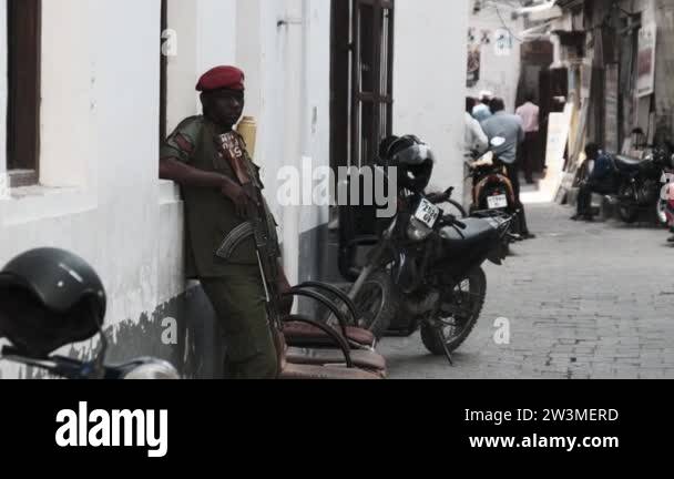 An armed African Soldier with Machine Gun on the Street in Poor Region ...