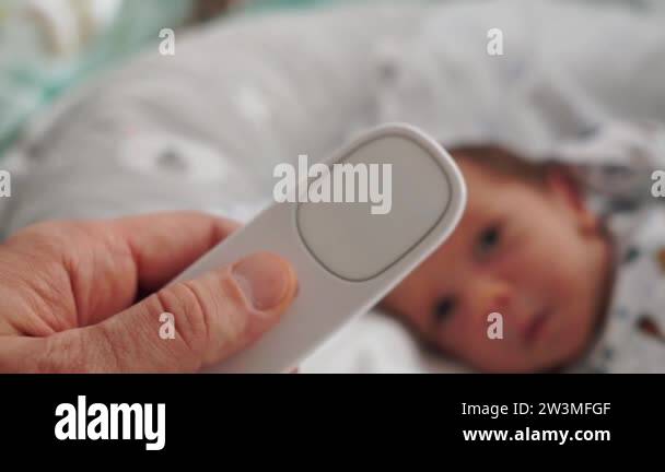 Mother or father measuring baby temperature with digital Non-contact ...