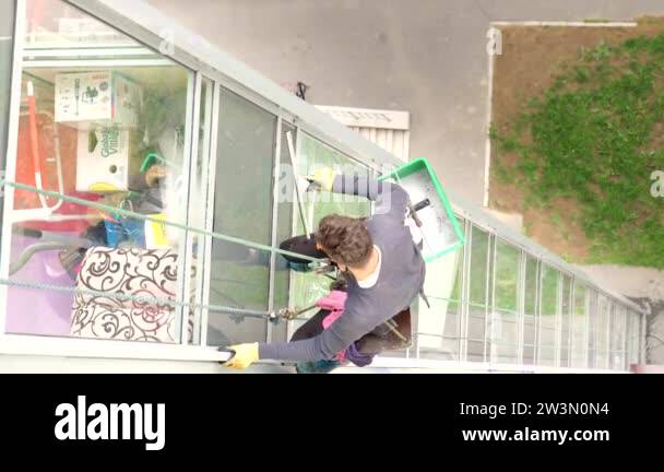 Video of mountaineer man washing Windows in multi-storey building ...