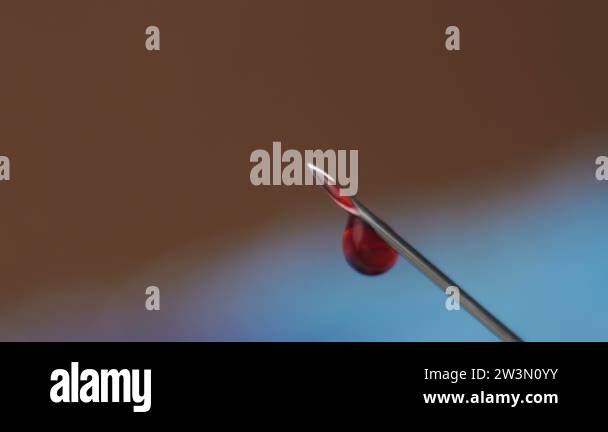 Close-up of a needle from a syringe with which a vaccine is dripping ...