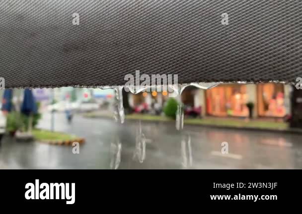 rain scenes, raindrops ragged along the edge of a sheet of plastic ...