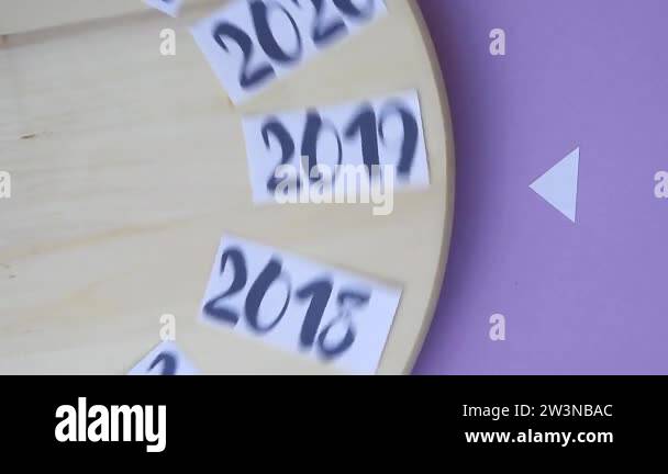 Years from 2014 to 2024 rotating on wooden board and stopped on 2021 ...