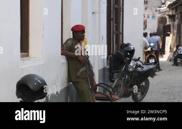 An armed African Soldier with Machine Gun on the Street in Poor Region ...