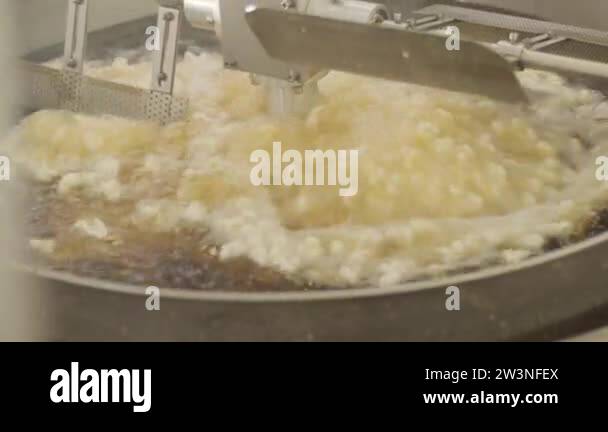 Production of potato chips and snacks. Industrial deep frying machine ...