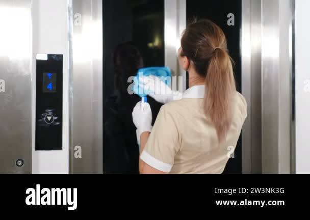 Cleaning in hotel. Hands in gloves cleaning and disinfecting elevator ...