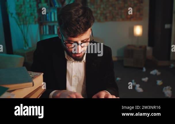 Concentrated office worker typing something on a retro typewriter he ...