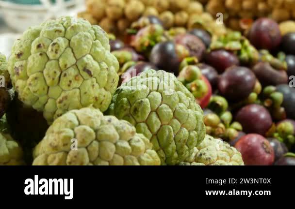 Assorted exotic fruits on stall in market. Bunch of sugar apples placed ...