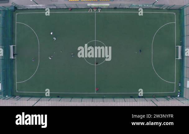 Players play football on a green football field with white markings ...