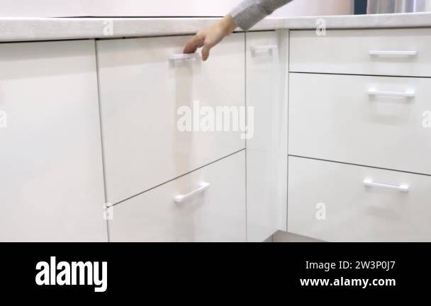 A womans hand opens a drawer in the kitchen table . Bright kitchen ...