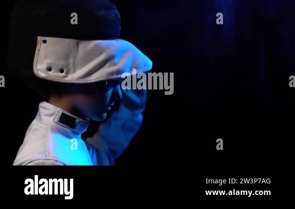 Side view of young fencer guy putting on sports mask helmet. Young ...
