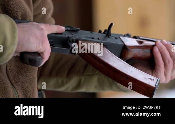 a man holds a Kalashnikov 47 rifle in his hands, raises the weapon up ...