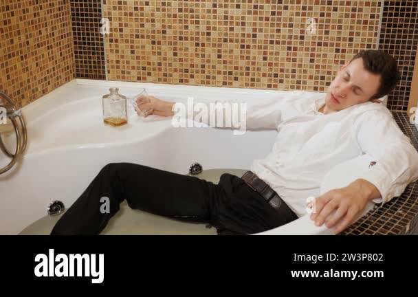 drunk man with alcohol is lying in a bath with water Stock Video ...