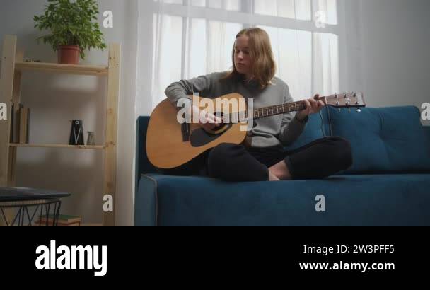 The girl runs the fingers of her right hand over the strings several ...