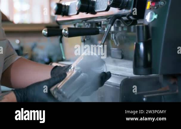young barista in gloves processes transparent glass glasses for ...
