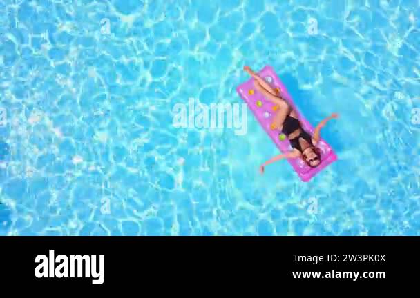 Fitted pretty girl in bikini chilling on inflatable pink mattress in ...