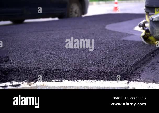 Close-up,working men shoveling black gravel for laying asphalt on the ...
