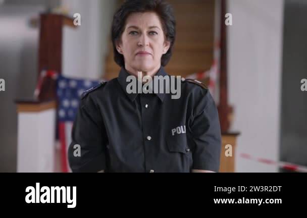 Serious Caucasian policewoman looking at camera raising hands with ...