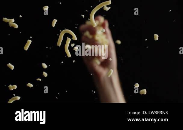 From below unrecognizable chef dropping and spreading ground cheese on ...