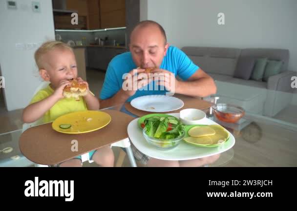 Family boys father and son eating hamburgers for breakfast. Gimbal ...
