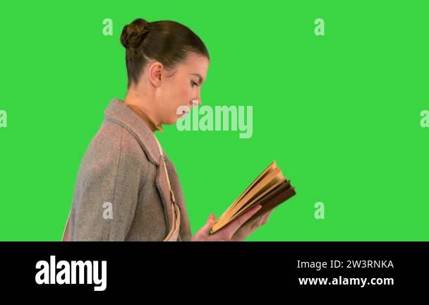 Woman walking and reading a book on a Green Screen, Chroma Key Stock ...