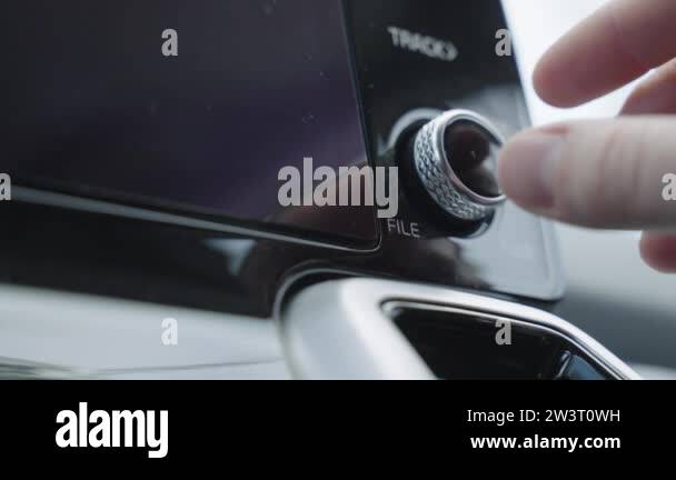 Male hand adjusts the tuning of the car radio. Close up of young man ...