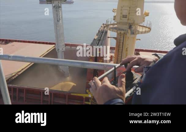 Loading wheat into a large cargo ship. Loading wheat with a conveyor ...