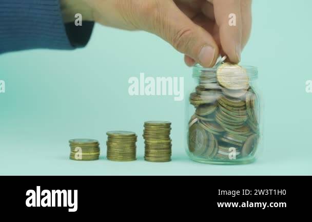 person hand puts coins into container near penny piles Stock Video ...