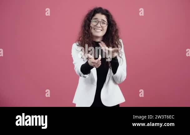 The young adult with curly hair gestures with her hands in front of her ...