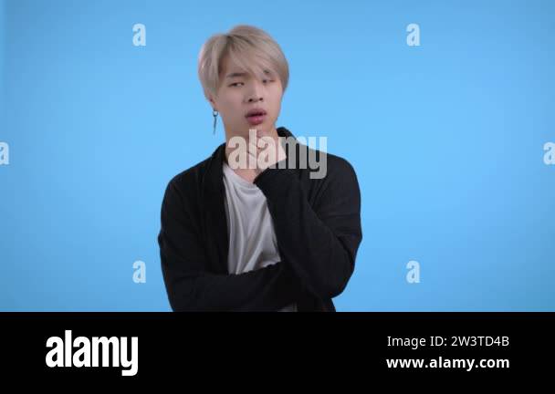 Thinking asian man looking up and around on blue background. Pensive ...