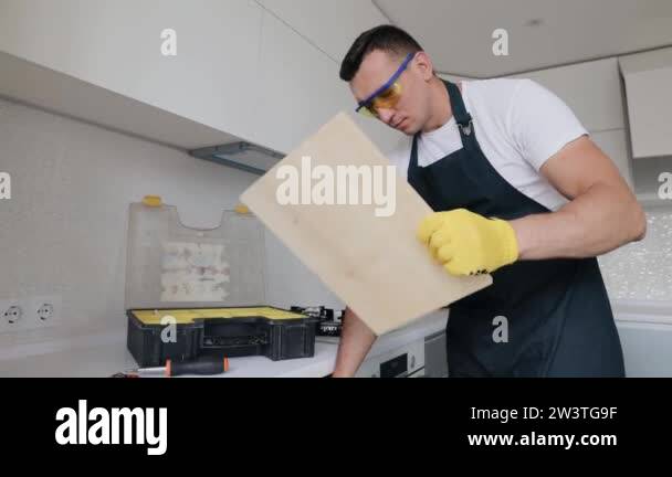 Successful furniture assembly worker adjusting shelf. Finishes his job ...
