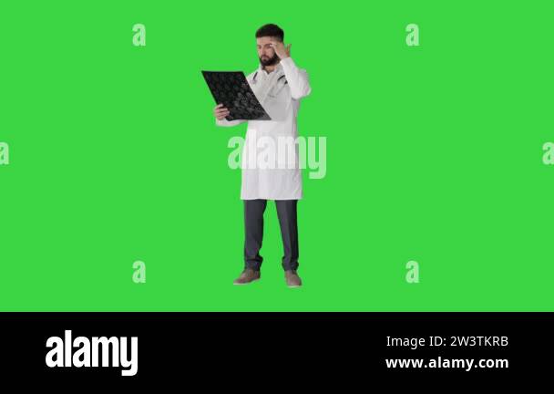 Arab doctor reading and reviewing a MRI brain scan on a Green Screen ...