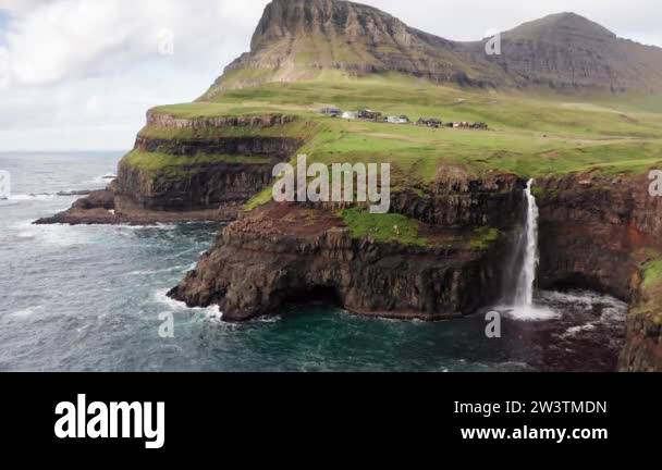 Stunning waterfall splashing from cliff aerial view. Mulafossur ...