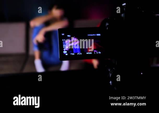 A tilt up camera shot of a camera recording an two young guys are ...