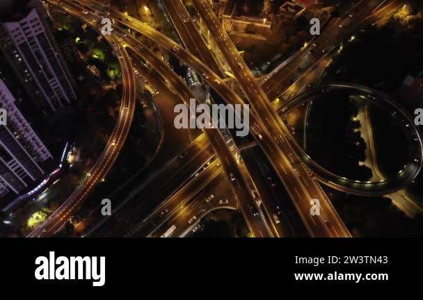 4k aerial view of highway and overpass traffic on interchange at night ...