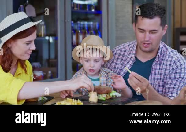 junk food, beautiful cheerful family with male children have fun eating ...