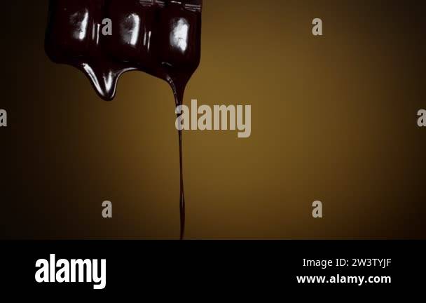 Chocolate bar with melted chocolate syrup dripping flowing over dark ...