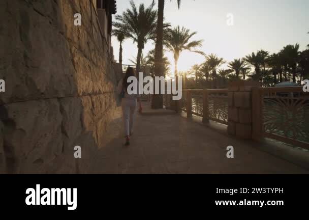 Following a woman on riverfront in luxury neighborhood in Dubai. Luxury ...