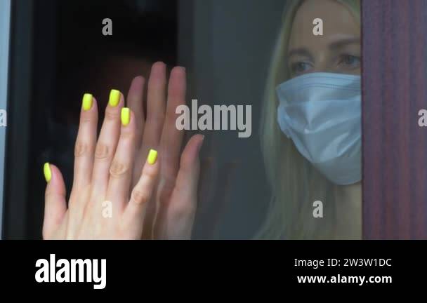 Two girls, sisters touch their hands with their palms through a glass ...