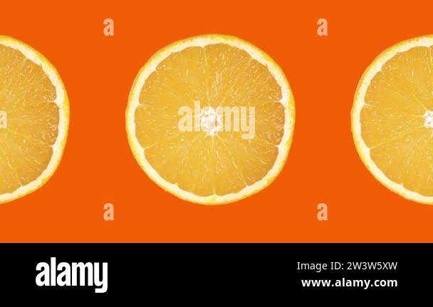 footage of spinning rotating slice of ripe juicy orange on yellow ...