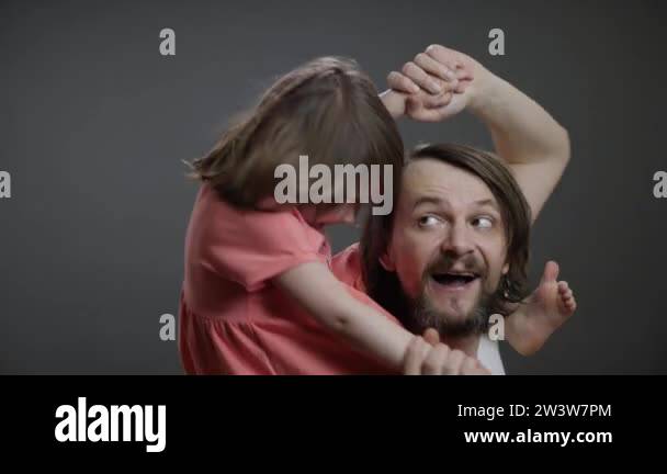 Piggyback ride on daddy. Young father throws his daughter hanging on ...