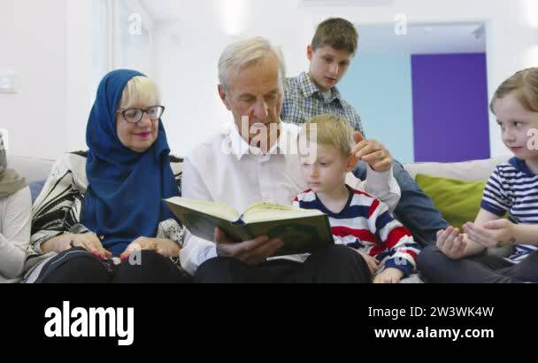 Traditional muslim family grand parents with children reading Quran and ...