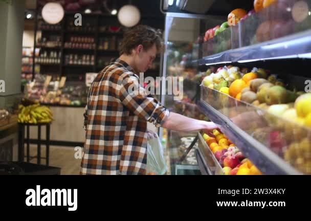 Man selecting fresh fruits in grocery store produce department and ...