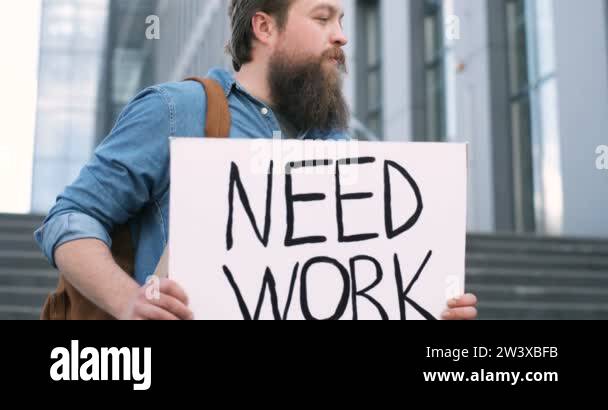 Close up of Caucasian young jobless man with beard standing outdoor at ...